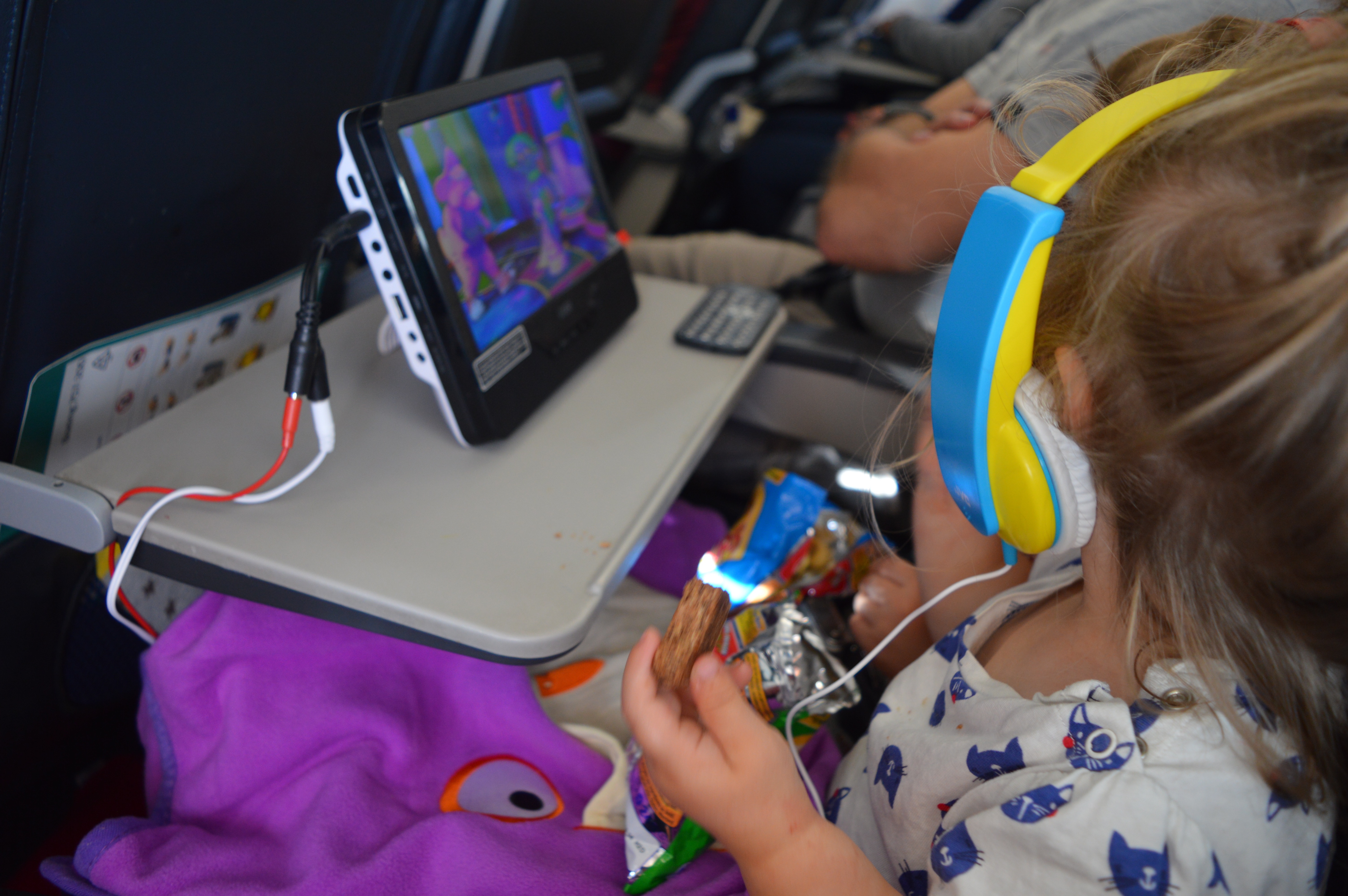 Toddlers watching DVD players on a plane - There We Go